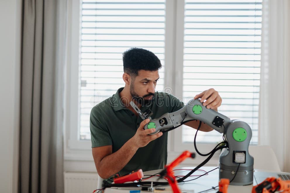 Young Engineer Building and Programming a Robotic Arm at Home. Stock ...