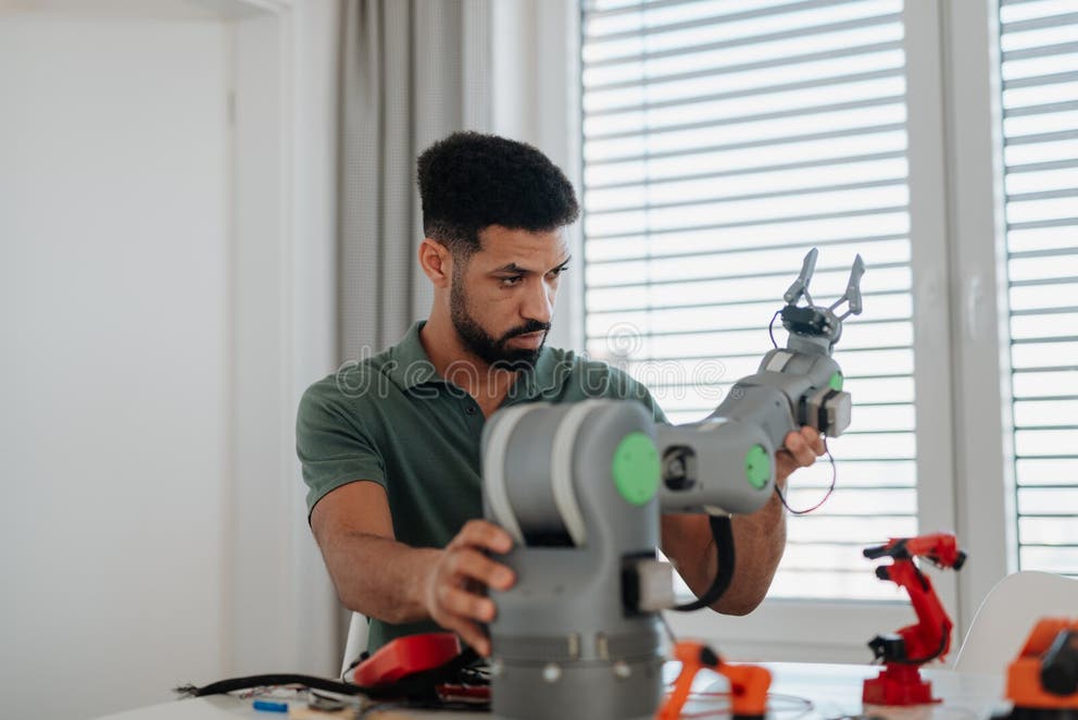Young Engineer Building and Programming a Robotic Arm at Home. Stock ...