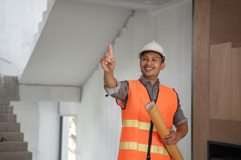 Confident Young Engineer Planning Work with Blueprints in Modern ...
