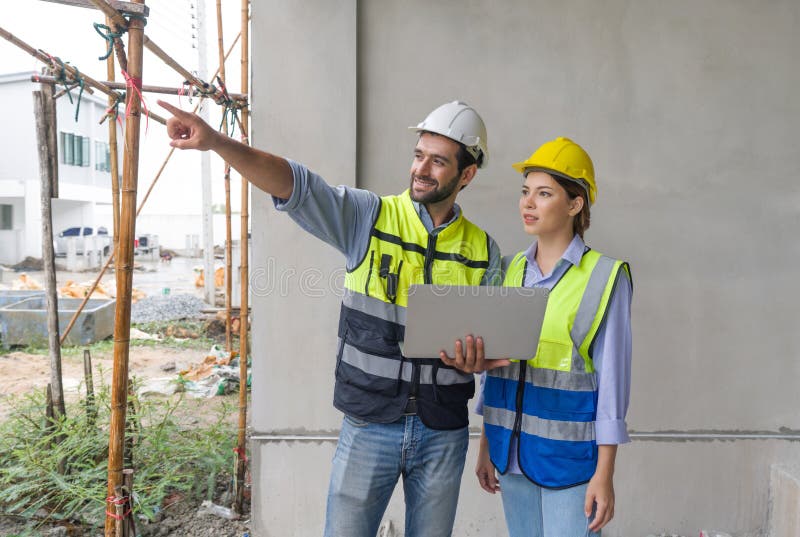 Young Engineer in a Construction Helmet and Safety Vest Explaining To ...