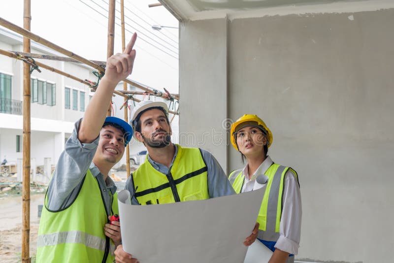 Young Engineer in a Construction Helmet and Safety Vest Explaining To ...