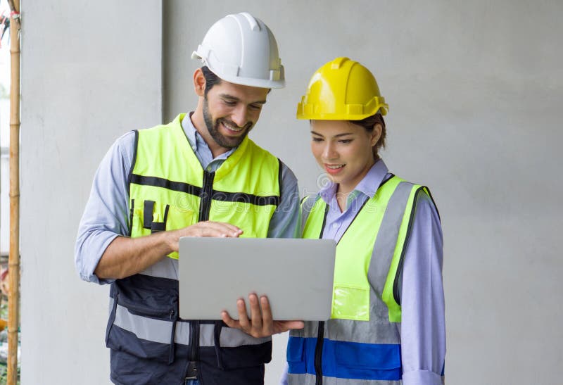 Young Engineer with Laptop Computer Explain To Foreman about a Floor ...