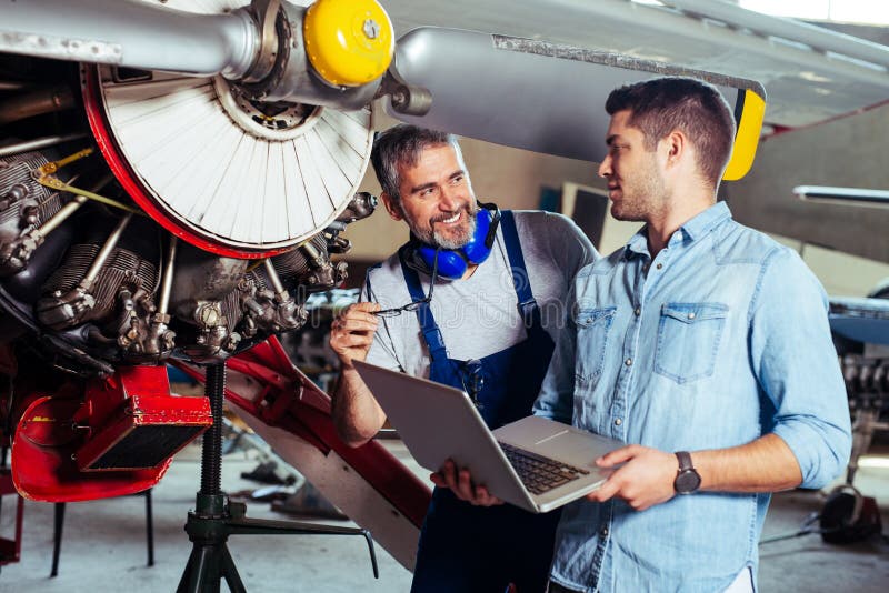 Engineer Looking at Laptop for Maintenance an Airplane. Stock Photo ...