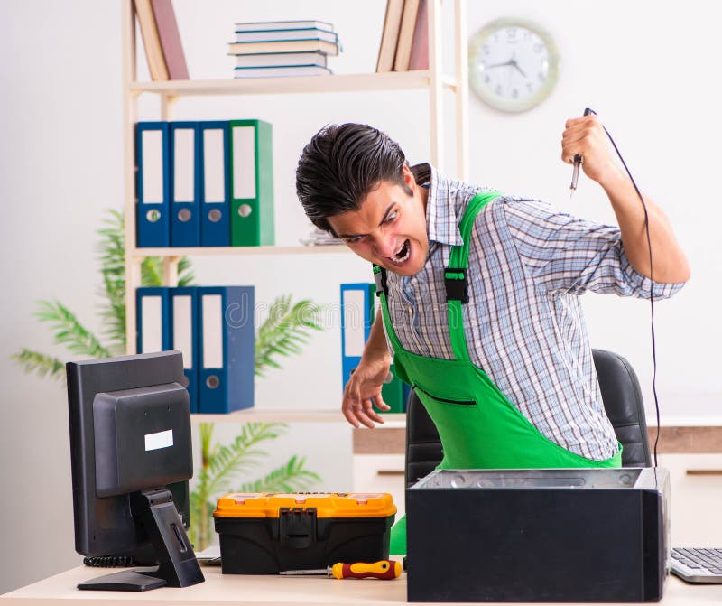 Young Engineer Repairing Broken Computer at the Office Stock Photo ...