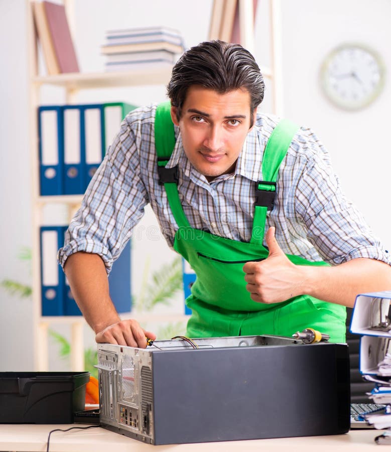 Young Engineer Repairing Broken Computer at the Office Stock Photo ...