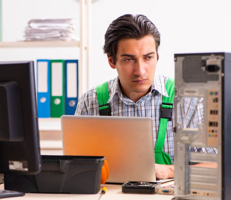 Young Engineer Repairing Broken Computer at the Office Stock Image ...