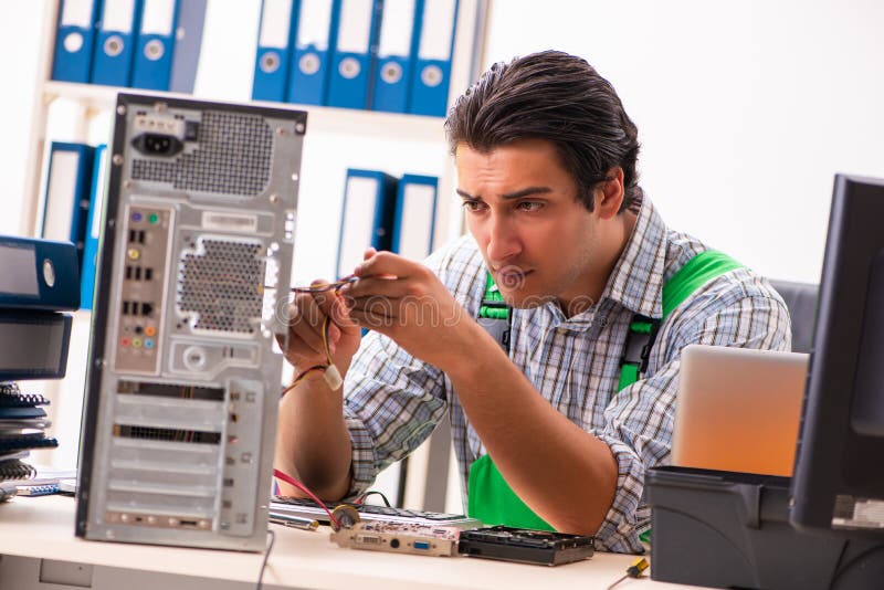 The Young Engineer Repairing Broken Computer at the Office Stock Image ...