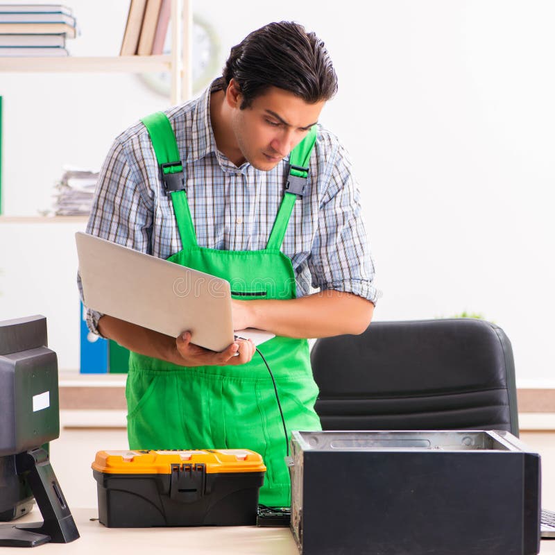 Young Engineer Repairing Broken Computer at the Office Stock Photo ...