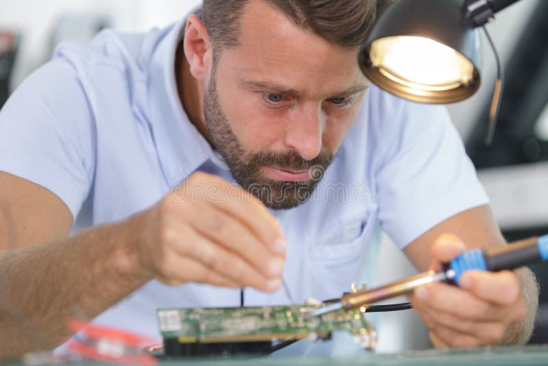 Young Engineer Repairs Electronic Equipment in Research Facility Stock ...