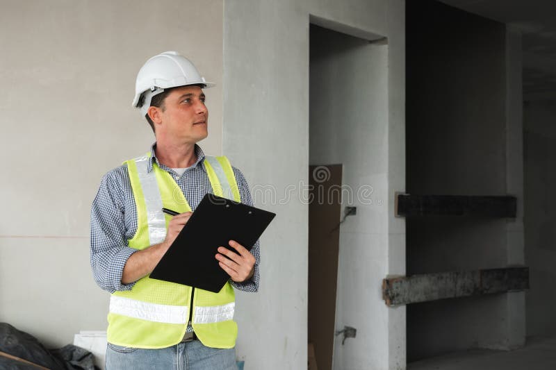 Young Engineer at Construction Site Wearing Safety Gear and Holding ...