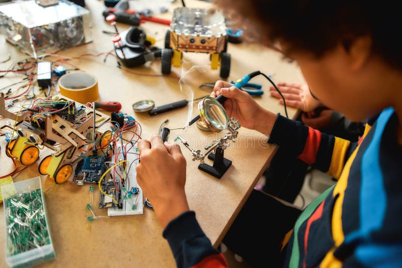 Improvement. Close Up of Young Engineer Using Soldering Iron To Join ...