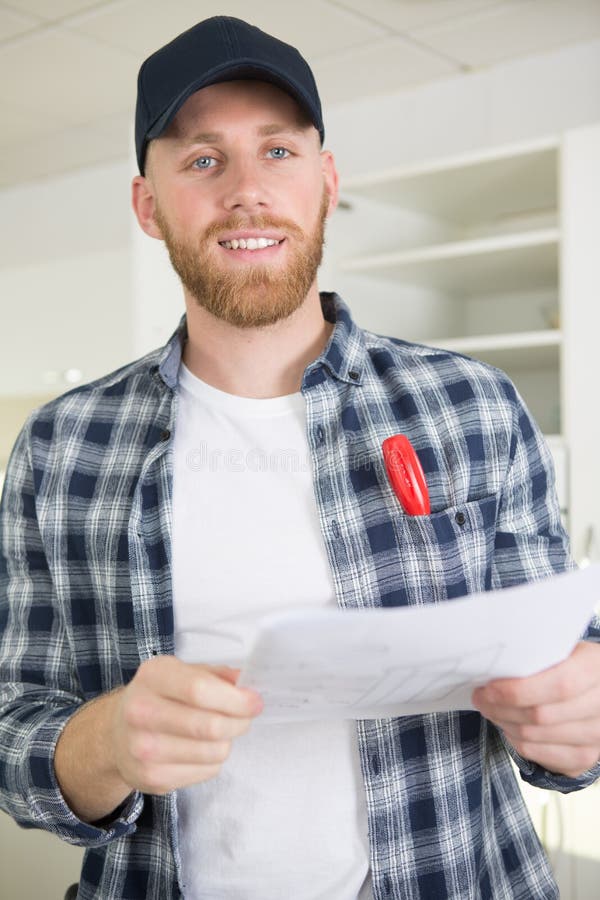 Young Engineer Working on Construction Site and Holding Blueprint Stock ...