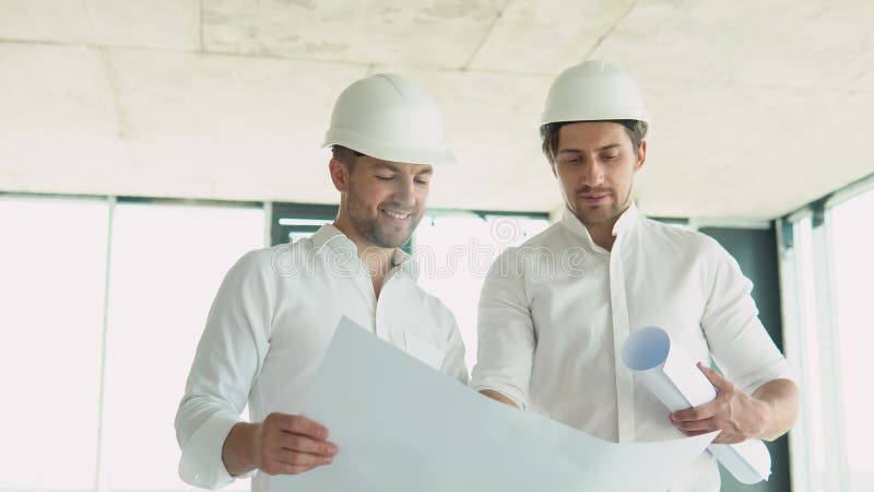 Two Men in Helmet Look at the Plan of the Building Stock Video - Video ...