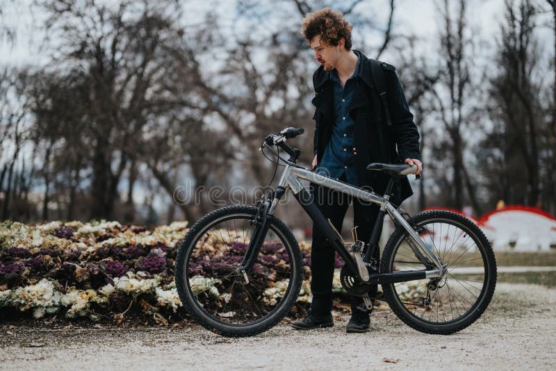 Young Entrepreneur with a Bicycle Working Remotely in a Park Setting ...
