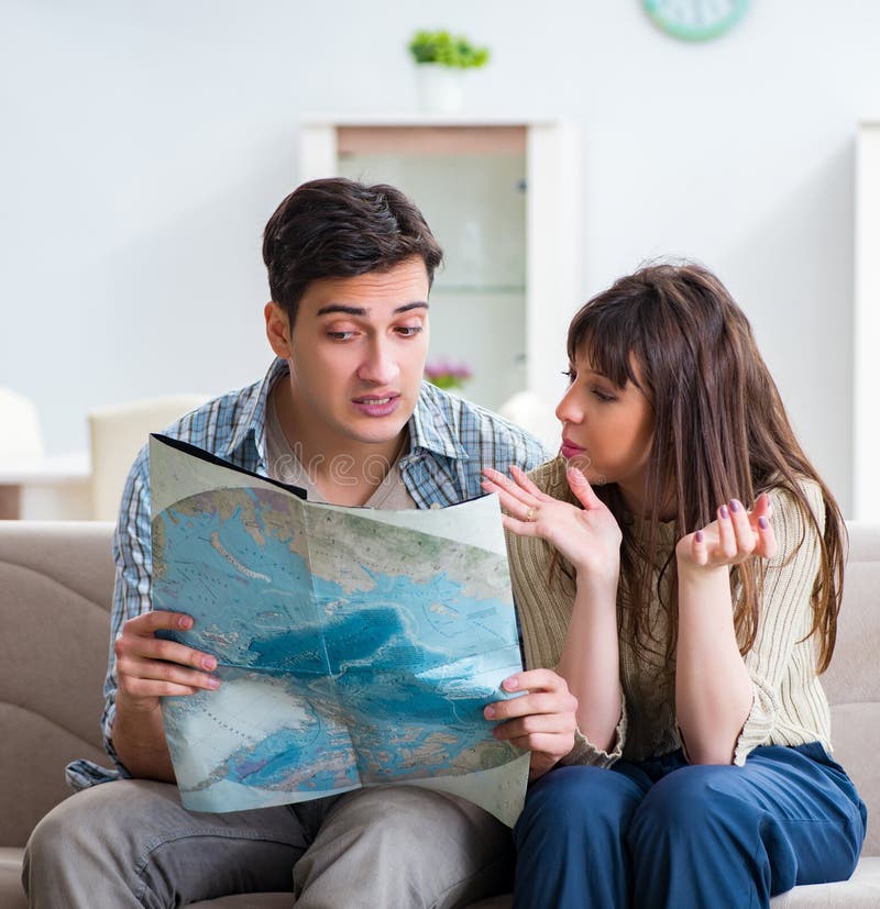 Young Family Discussing Travel Plans with Map Stock Photo - Image of ...