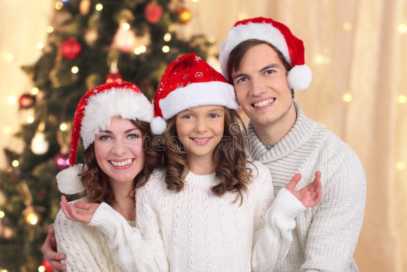 Young Family in Front of Christmas Tree Stock Image - Image of present ...
