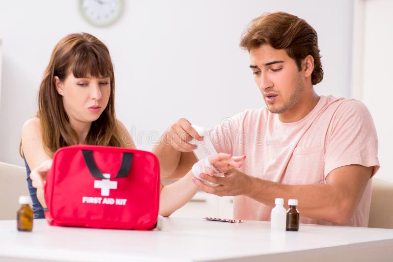 The Young Family Getting Treatment with First Aid Kit Stock Photo ...