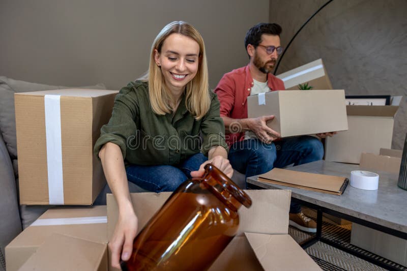 Young Family Looking Involved while Packing Boxes for the Move Stock ...
