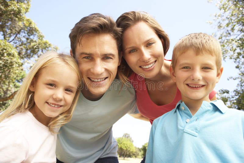 Young Family Outdoors in Park Looking into Camera Stock Image - Image ...