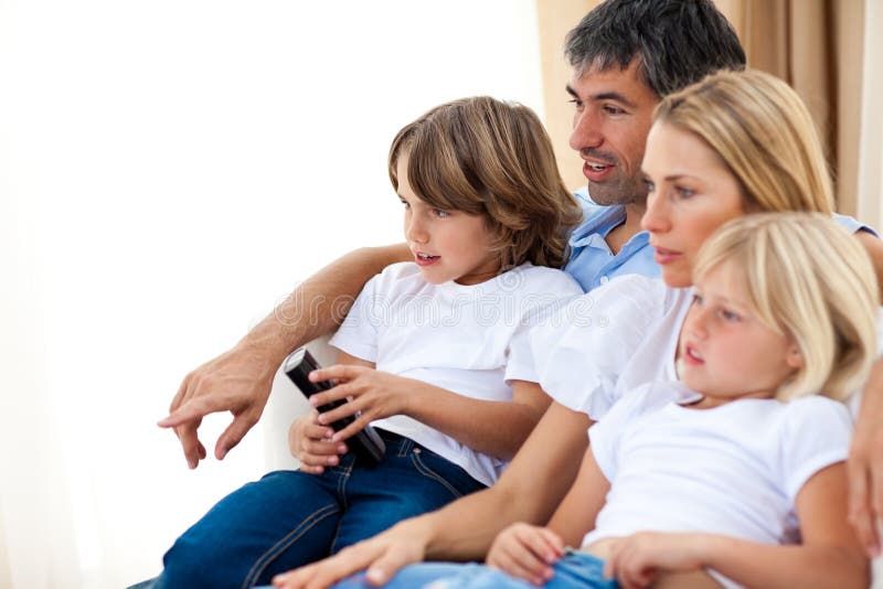 Family Sitting in Living Room with Remote Control Stock Image - Image ...