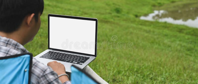 A Young Farmer is Using a Computer Laptop in a Green Yard. Stock Photo ...