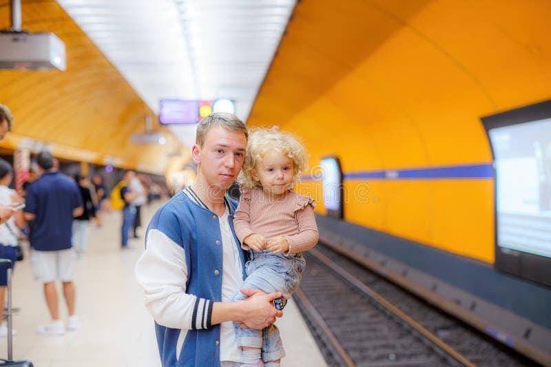 A Young Father with a Child is Waiting for a Train in an Underground ...
