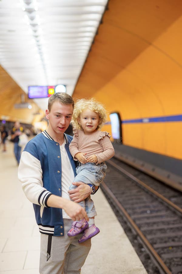 A Young Father with a Child is Waiting for a Train in an Underground ...