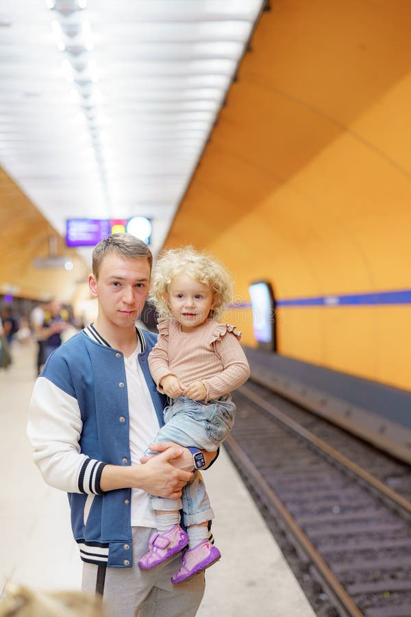 A Young Father with a Child is Waiting for a Train in an Underground ...
