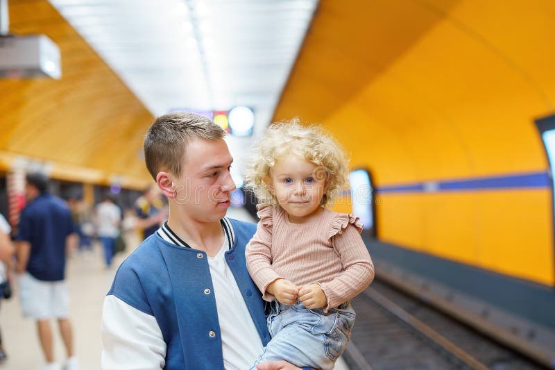 A Young Father with a Child is Waiting for a Train in an Underground ...