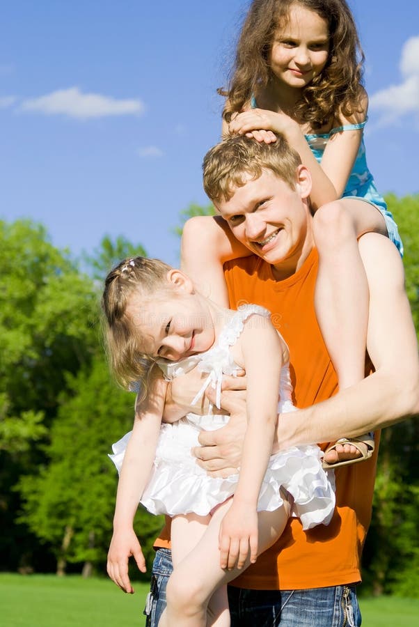 Young father with children stock image. Image of grass - 24892817