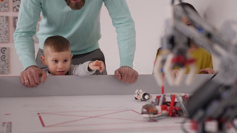 A Young Father and Son Control Robots Assembled from a Construction Kit ...