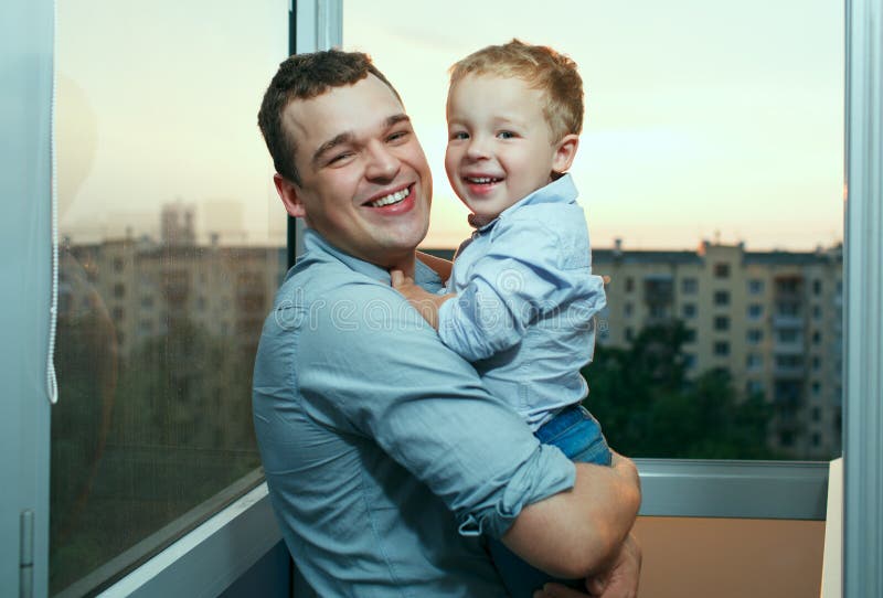 Young Father and Son Smiling on the Balcony. Stock Photo - Image of ...