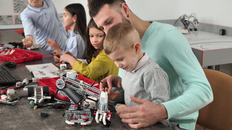 Young Father and Son Assemble a Construction Kit at a Robotics School ...