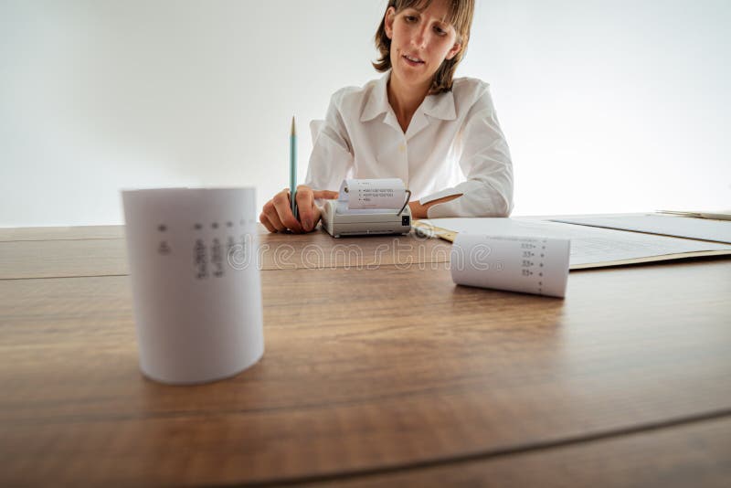 Young Female Accountant Using Adding Machine Working at Her Desk Stock ...
