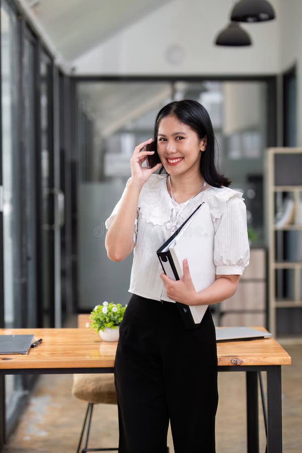 Young Female Accountant Using Telephone for Communication in Modern Office Environment Stock ...