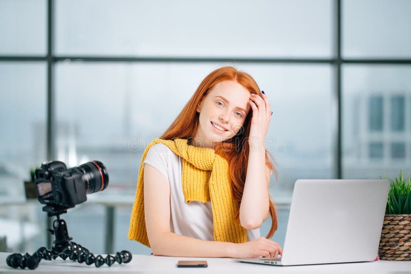 Young Female Blogger with Laptop and Book on Camera Screen Looking at ...