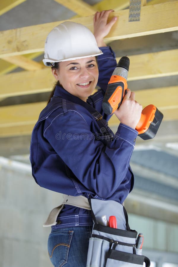 Young Female Construction Worker Using Drill To Build Ceiling Stock ...
