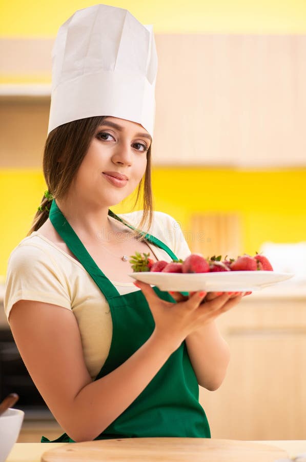 Young Female Cook Eating Strawberries Stock Photo - Image of apron ...