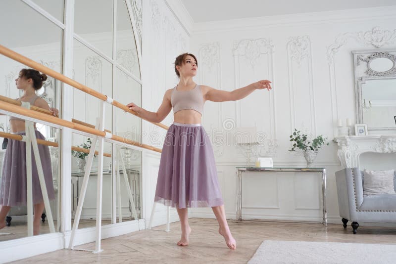 A Young Female Dancer is Engaged in Ballet Practice at a Ballet Machine ...