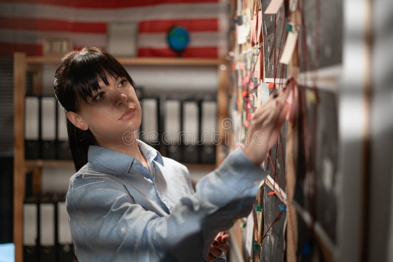 Young Female Detective Looking at Evidence Board. Stock Photo - Image ...