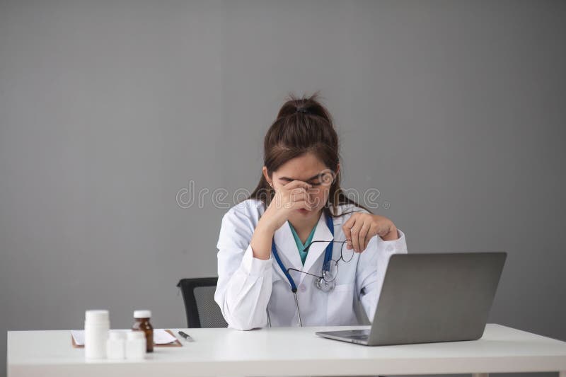 Young Female Doctor Looking at Laptop Computer and Tired from Work ...