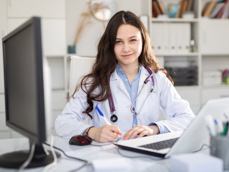 Young Female Doctor Trainee Making Important Notes for Work, Sitting at ...