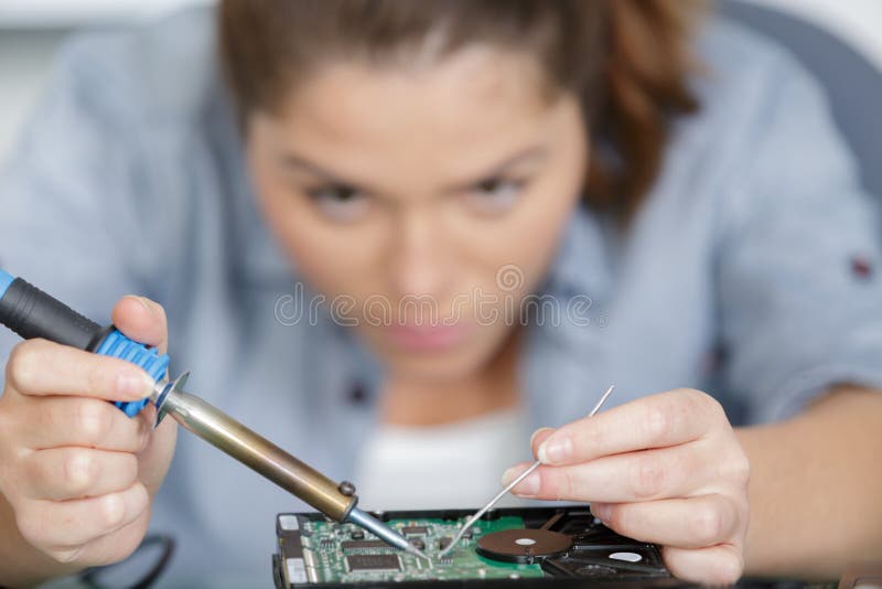 Young Female Electronic Engineer Soldering Computer Motherboard in ...