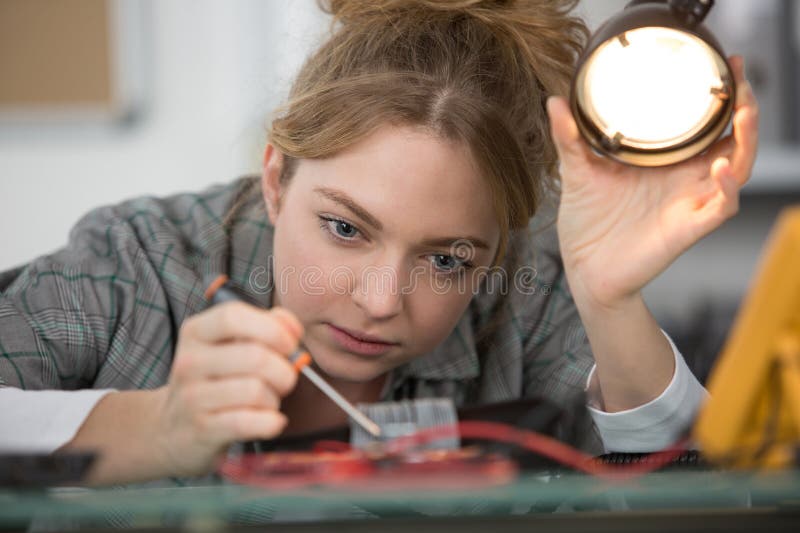 Young Female Electronic Engineer Soldering Computer Motherboard in ...