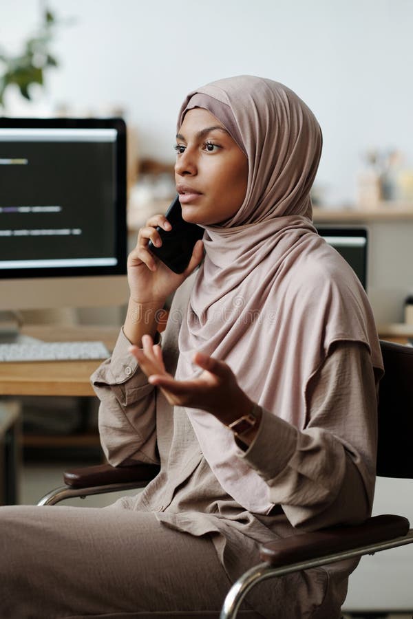 Young Female it Engineer or Programmer in Hijab Talking on Smartphone ...