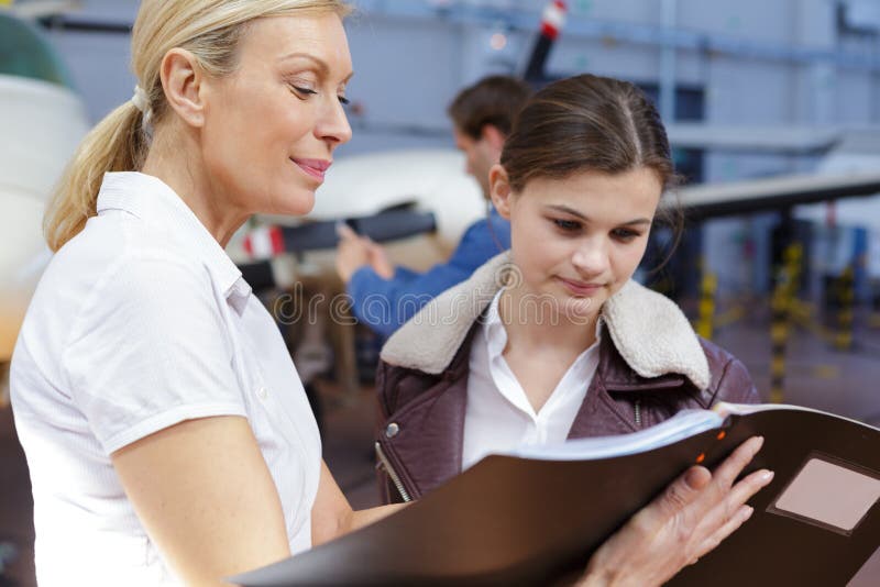 Young Female Engineer Reading Book from Teacher Stock Photo - Image of ...