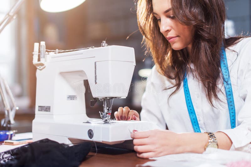 Young Female Fashion Designer Working on Sewing Machine in a Workshop ...