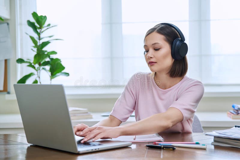 Young Female in Headphones Using Computer Laptop for Studying Stock ...
