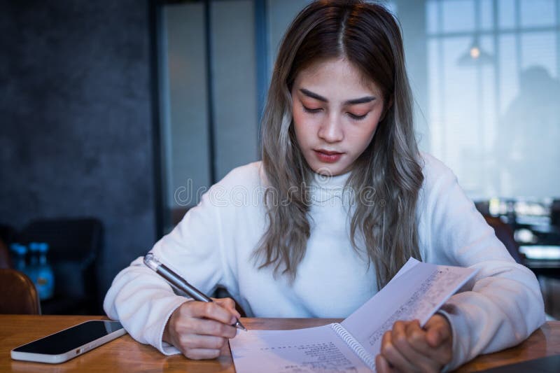 Young Female Looking through Her Notes in a Room Stock Image - Image of ...