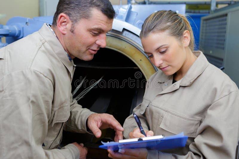 Young Female Machinist Writing on Clipboard Stock Image - Image of ...